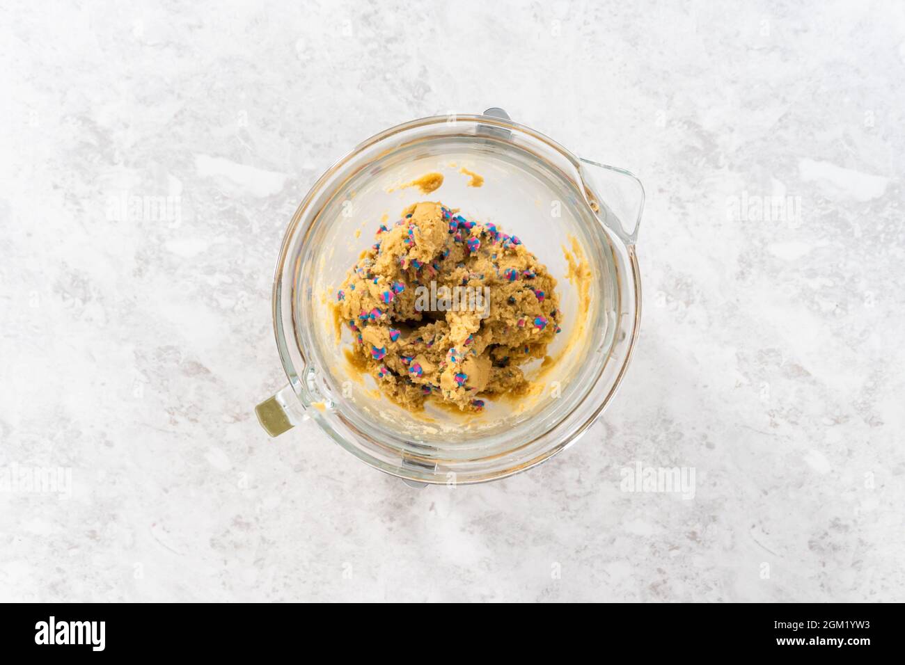 Flat lay. Cookie dough in a glass mixing bowl to prepare unicorn ...