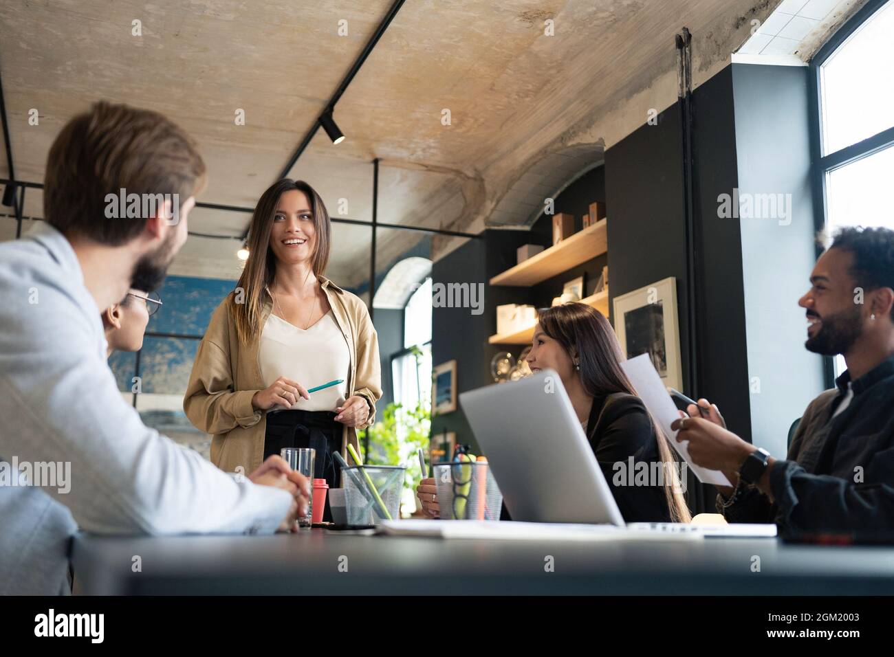 Female executive leader talking to happy diverse employees group at ...