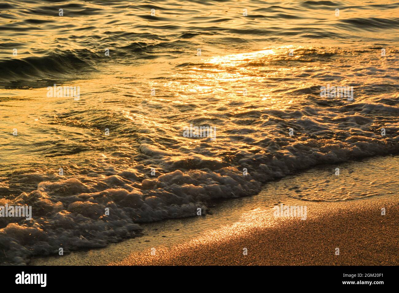 Colorful Waves and sand texture on the beach at sunset Stock Photo - Alamy
