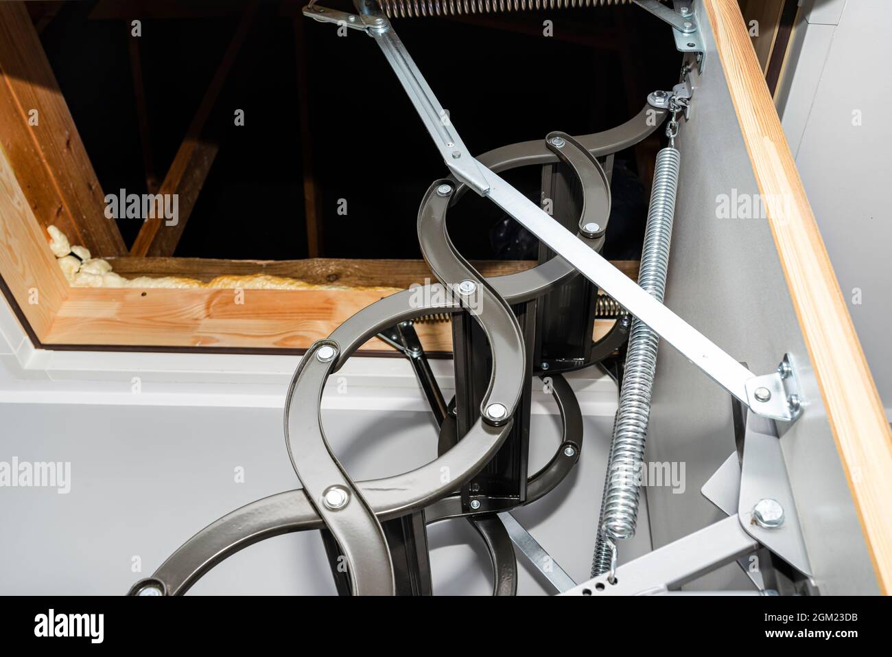 A spring tensioning mechanism that facilitates the opening of a metal ...