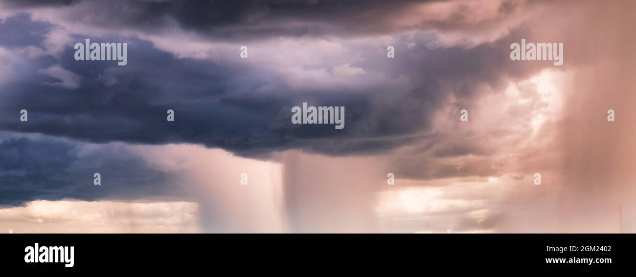 Heavy rainstorm in colorful stormy sky at evening. natural phenomenon ...