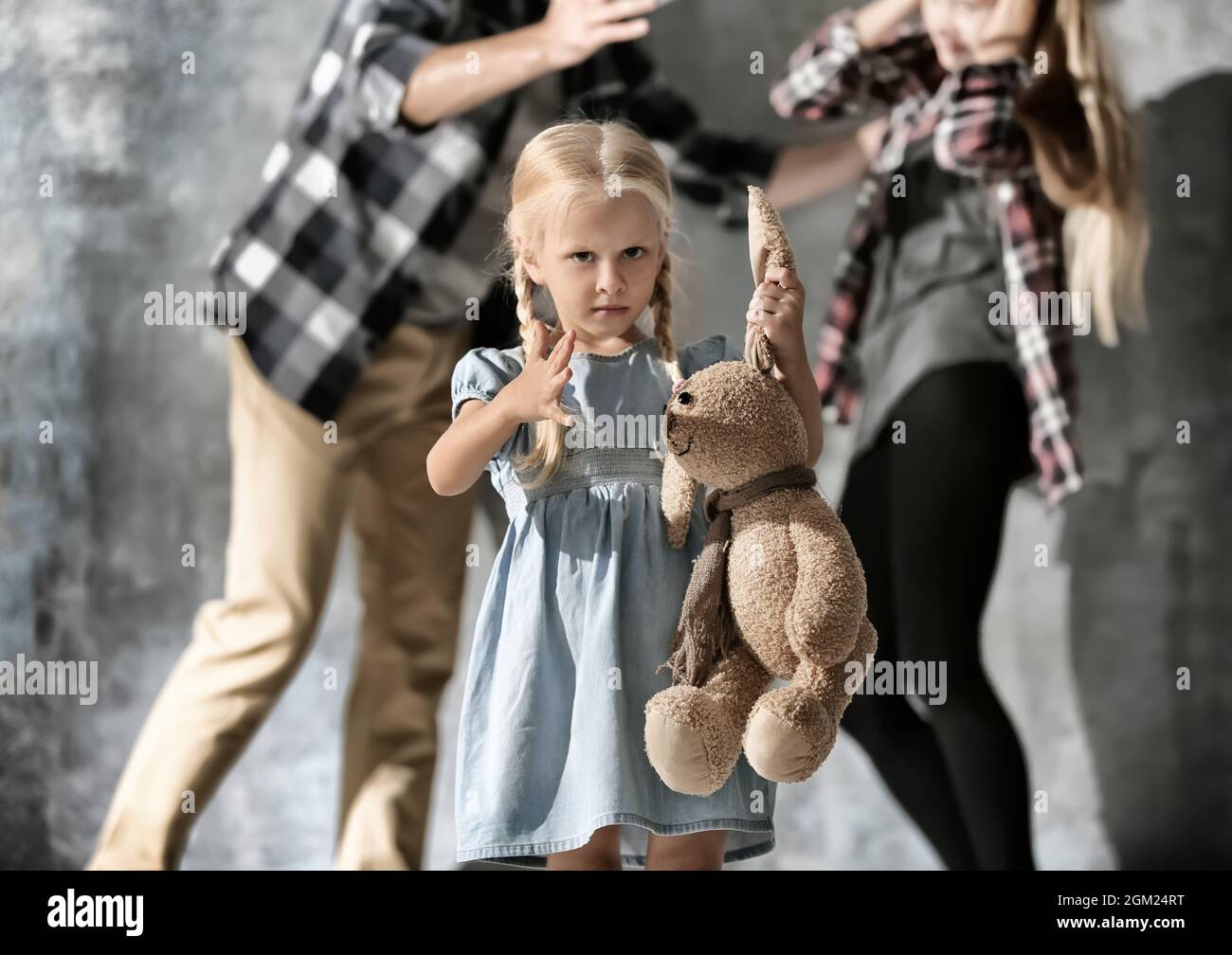Little girl with toy rabbit and man abusing woman on grey background ...