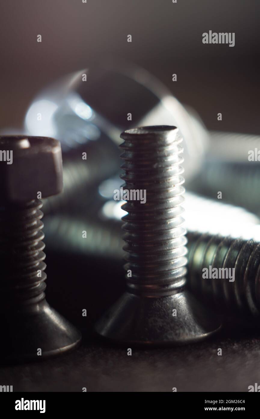 Vertical closeup of the bolts and screws on dark background Stock Photo ...