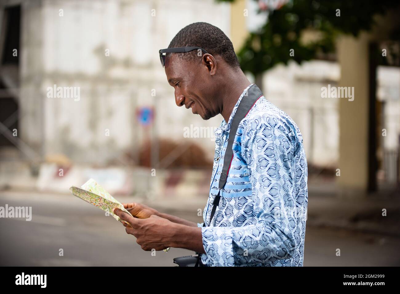 happy tourist holding and reading a map in the street smiling Stock ...