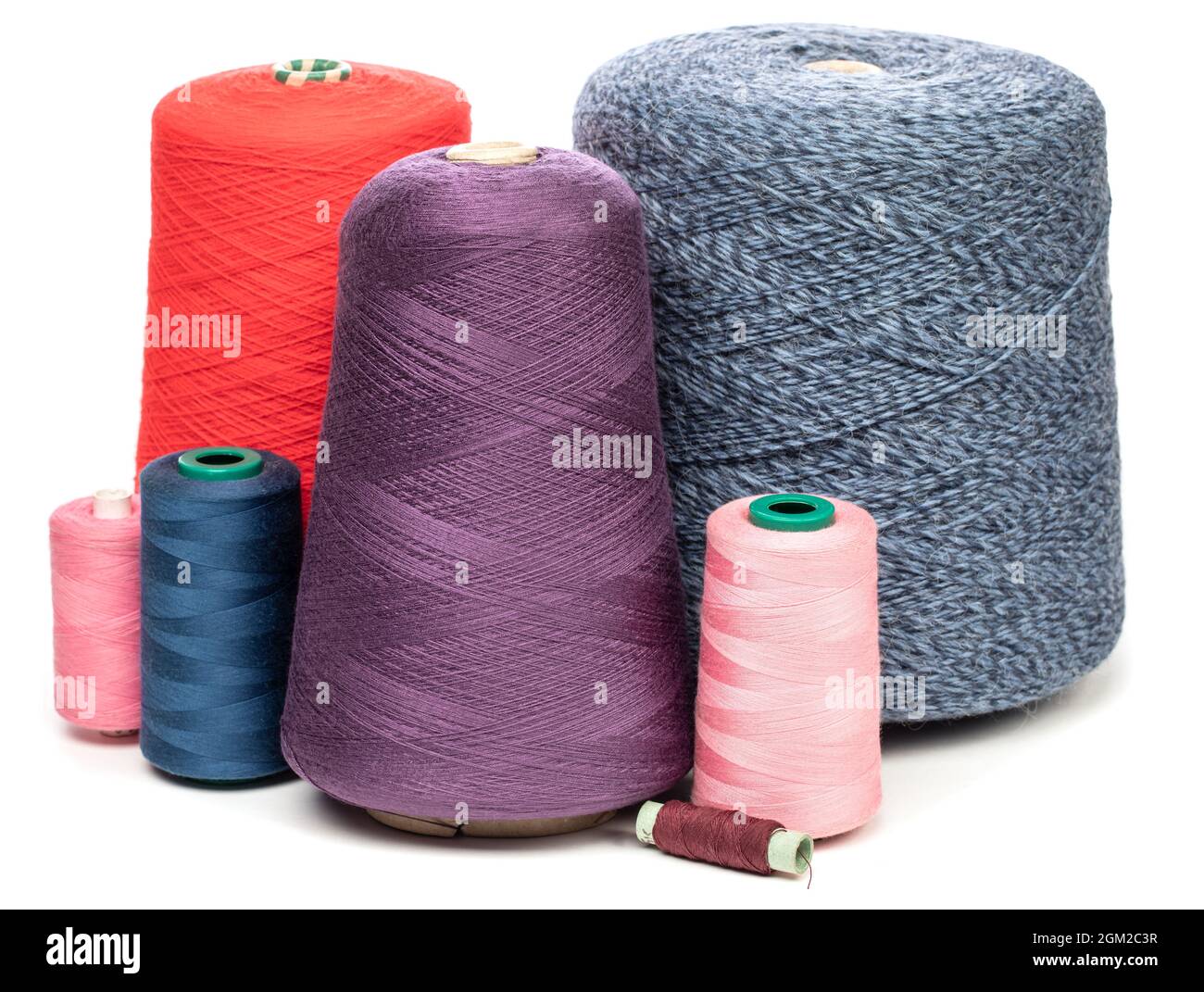 Cones and spools of synthetic or cotton threads on white background ...