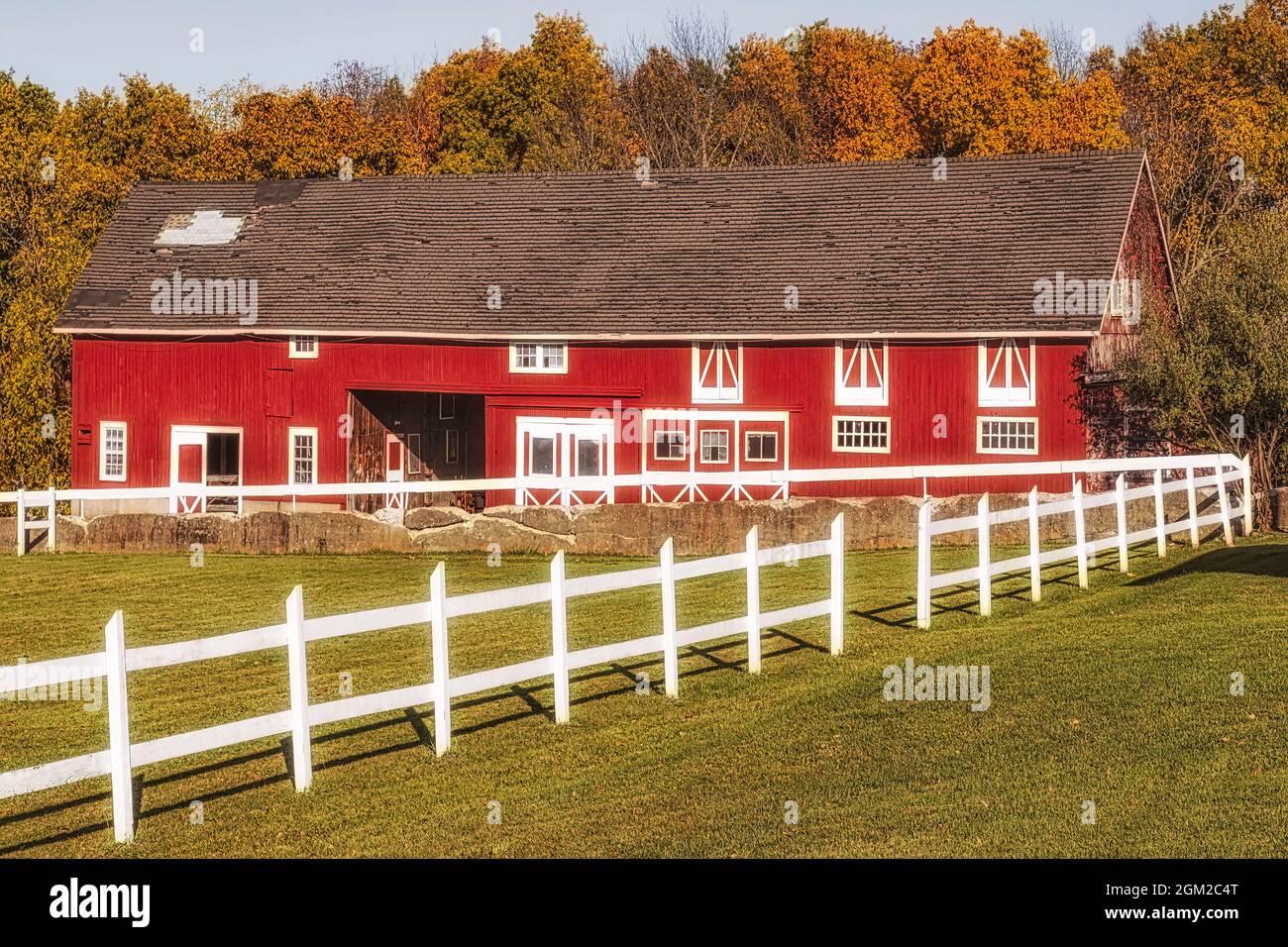 Red Barn In NJ - White wooden fence leads to a red barn with fall ...