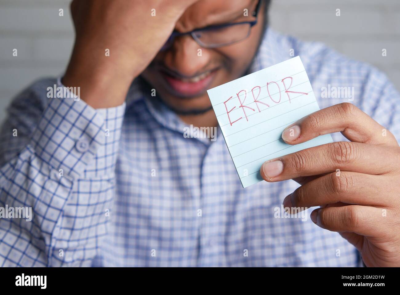 hand hold a sticky note with error text Stock Photo - Alamy
