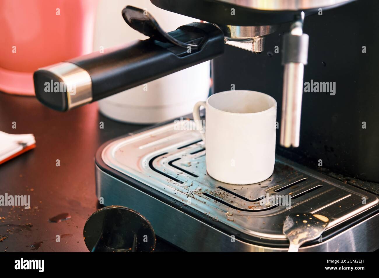 White espresso cup on espresso machine with messy and dirty bar counter ...