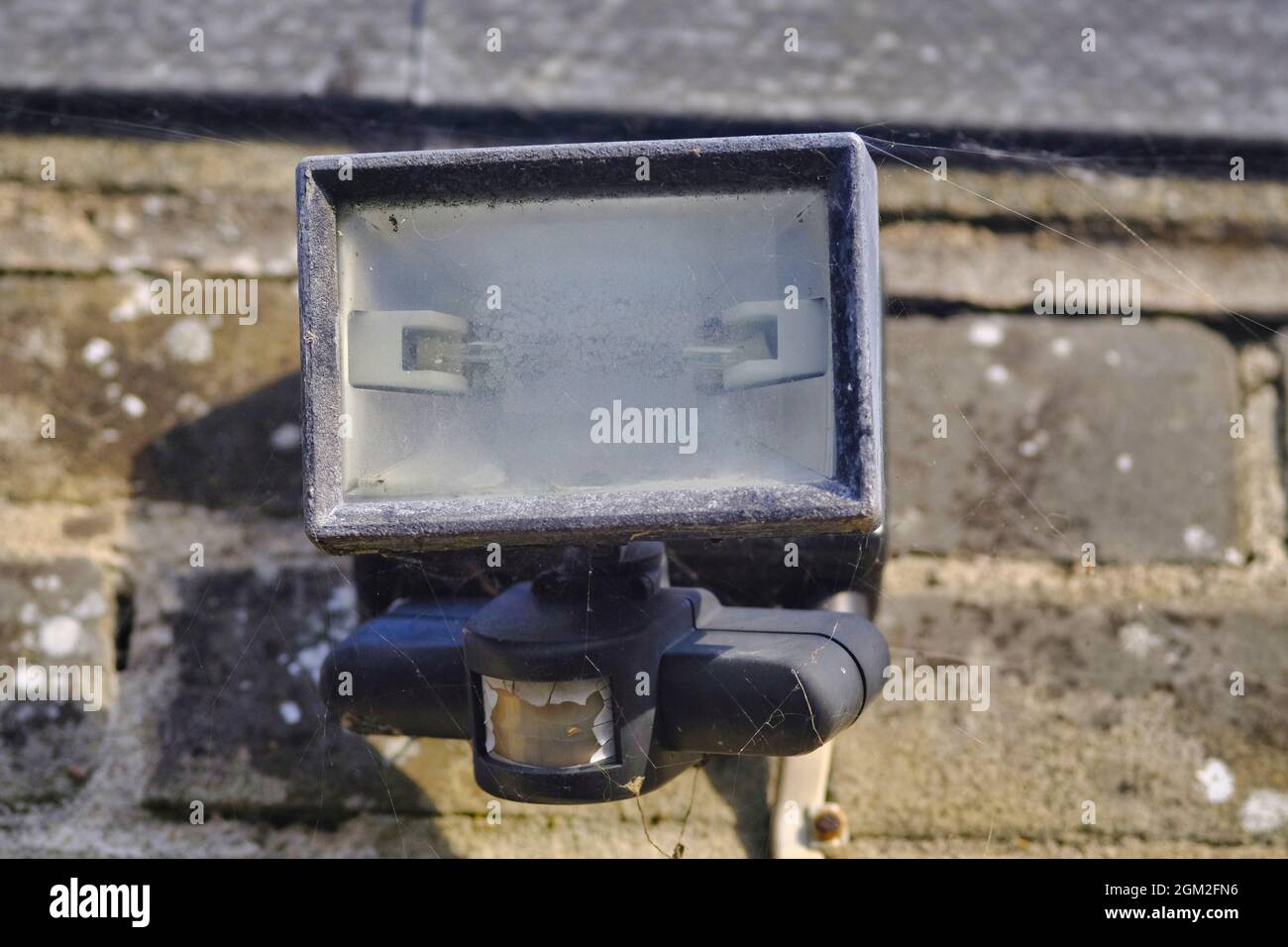 Broken down outdoor security light attached to brick wall Stock Photo ...