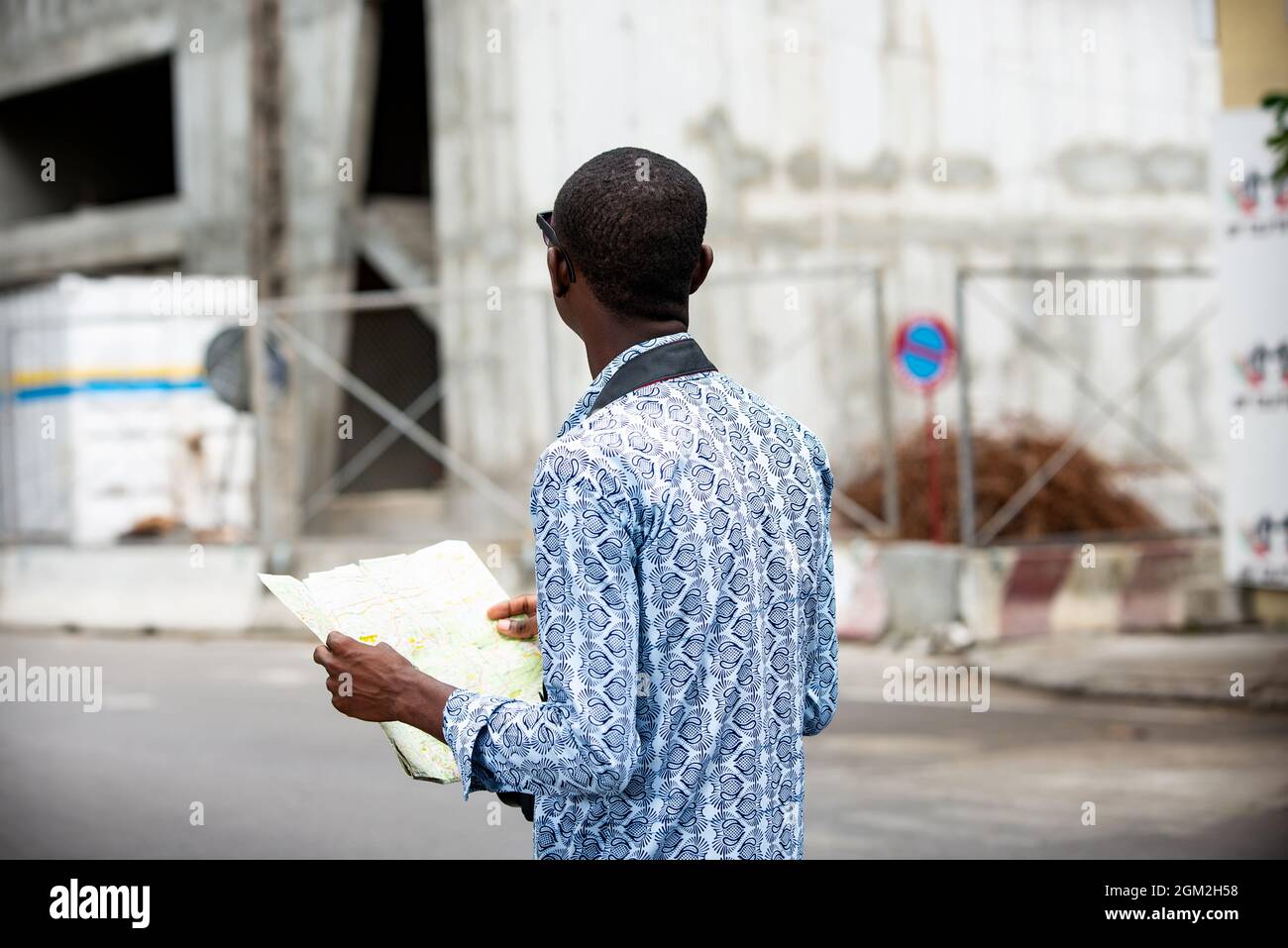 rear view of a young man holding a map of the city in hand Stock Photo ...