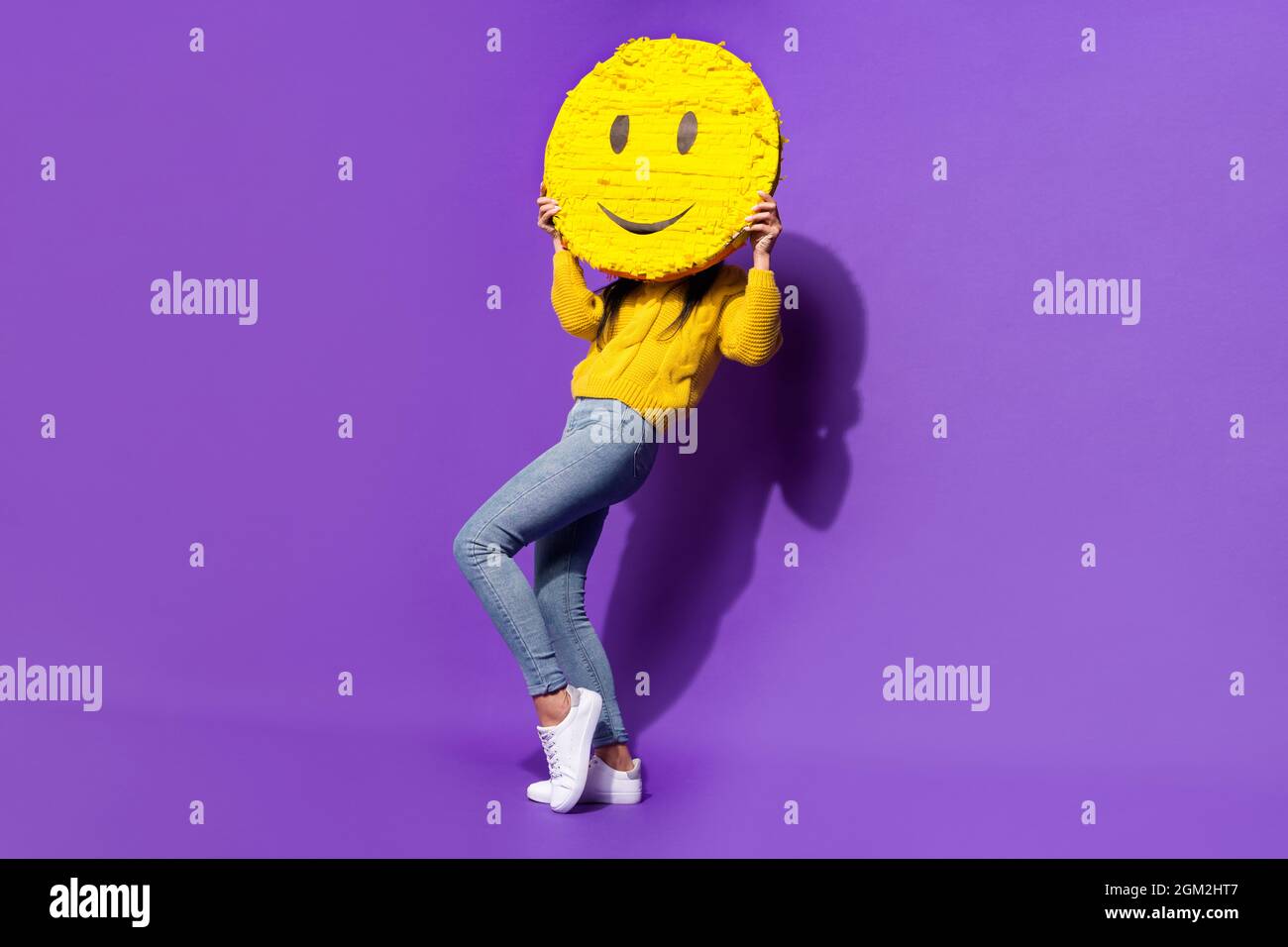 Full body portrait of satisfied person arms hold big emodji covering ...