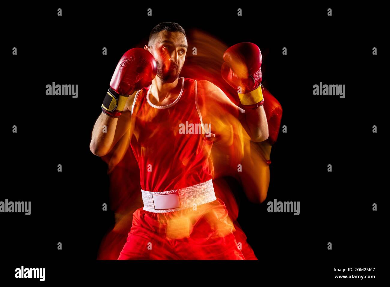 One professional male boxer training isolated over black backgrund in ...