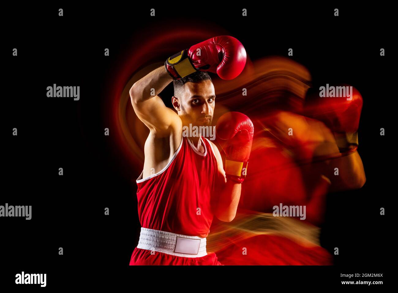 One professional male boxer training isolated over black backgrund in ...