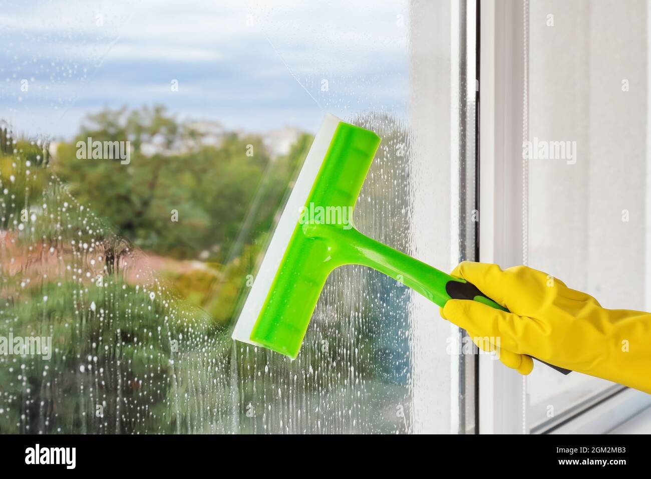 Cleaner washing window with squeegee Stock Photo - Alamy