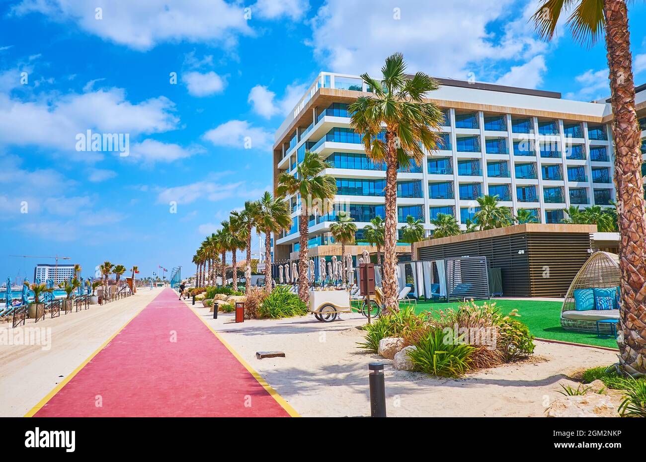 The seaside promenade with jogging track, sand beach, palm trees and ...