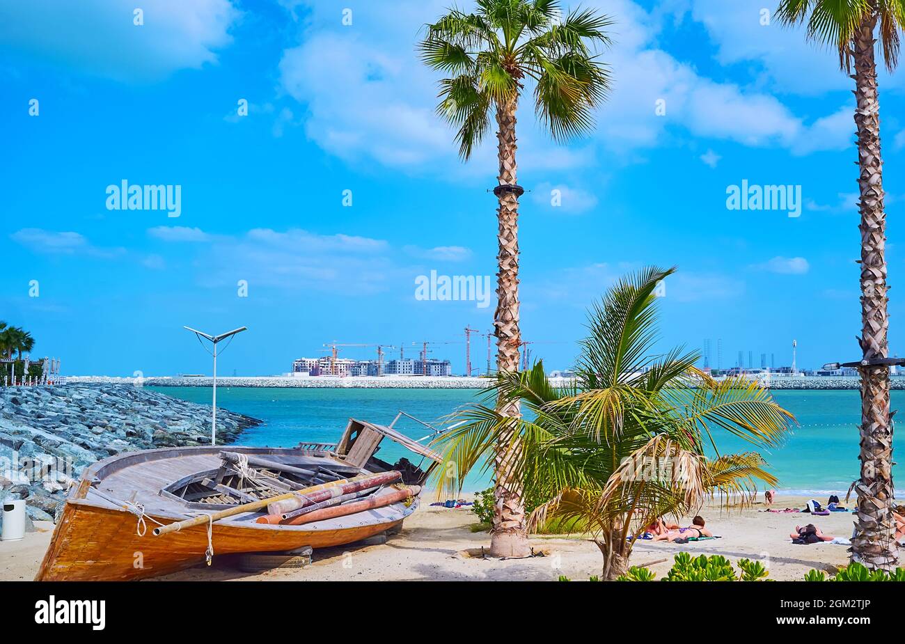 Walk the shore of La Mer beach and watch the old wooden boat, tall palm ...
