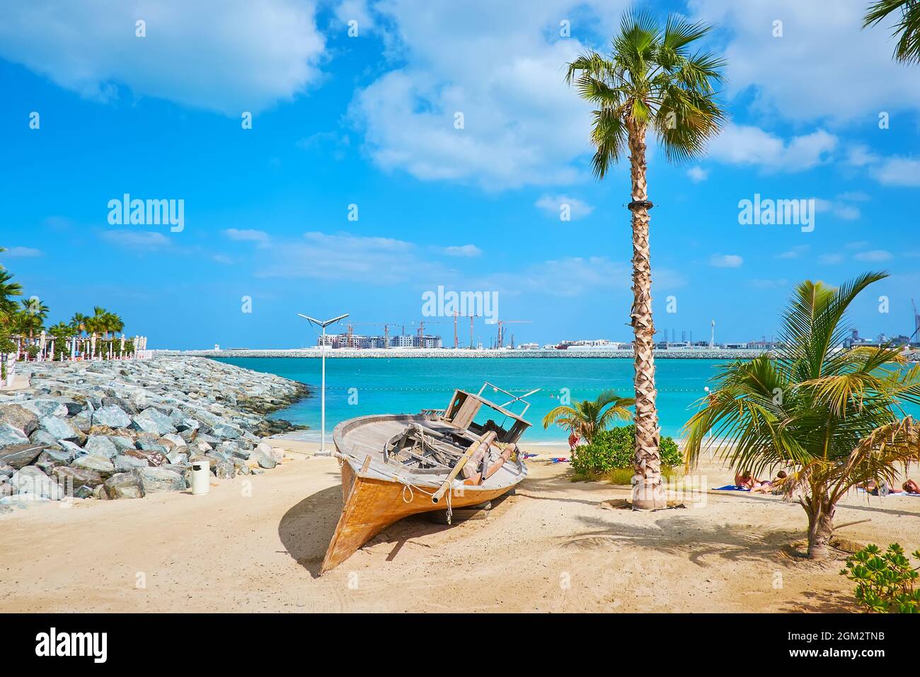 The picturesque coast of Persian Gulf with white sand, green palms of ...