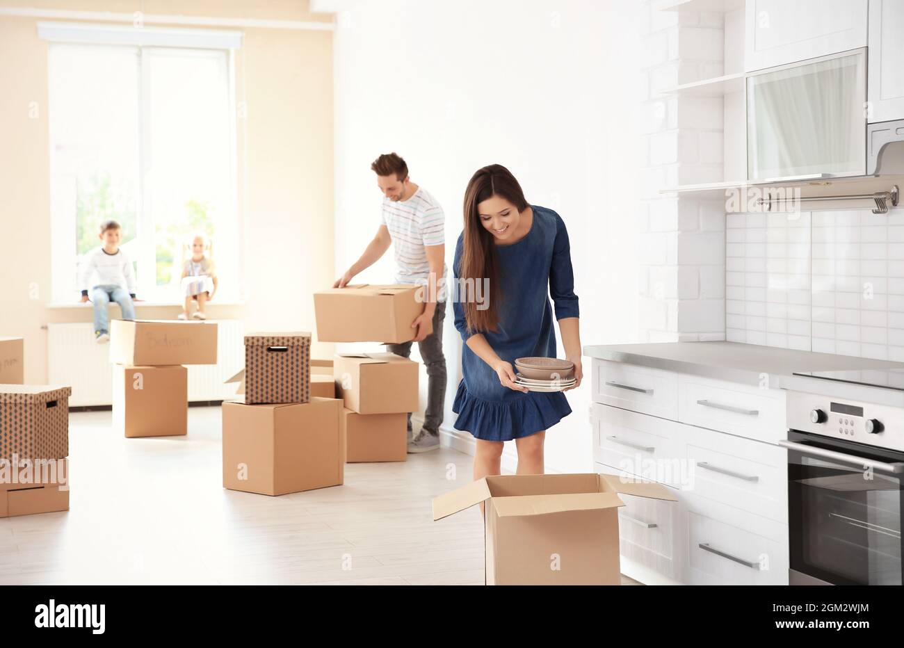 Family unpacking boxes in their new home Stock Photo - Alamy