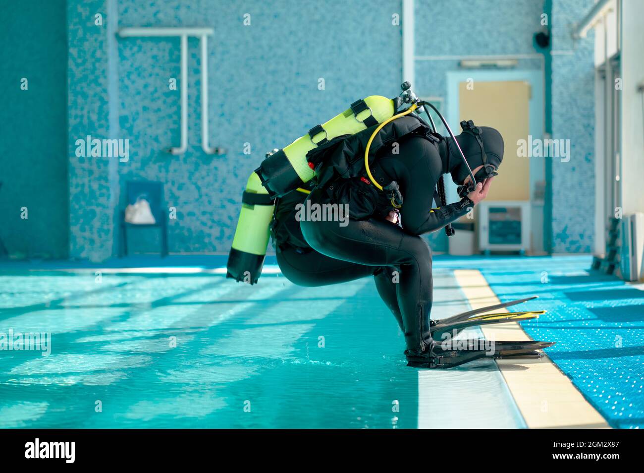Male divers in scuba gear jump into the pool Stock Photo - Alamy