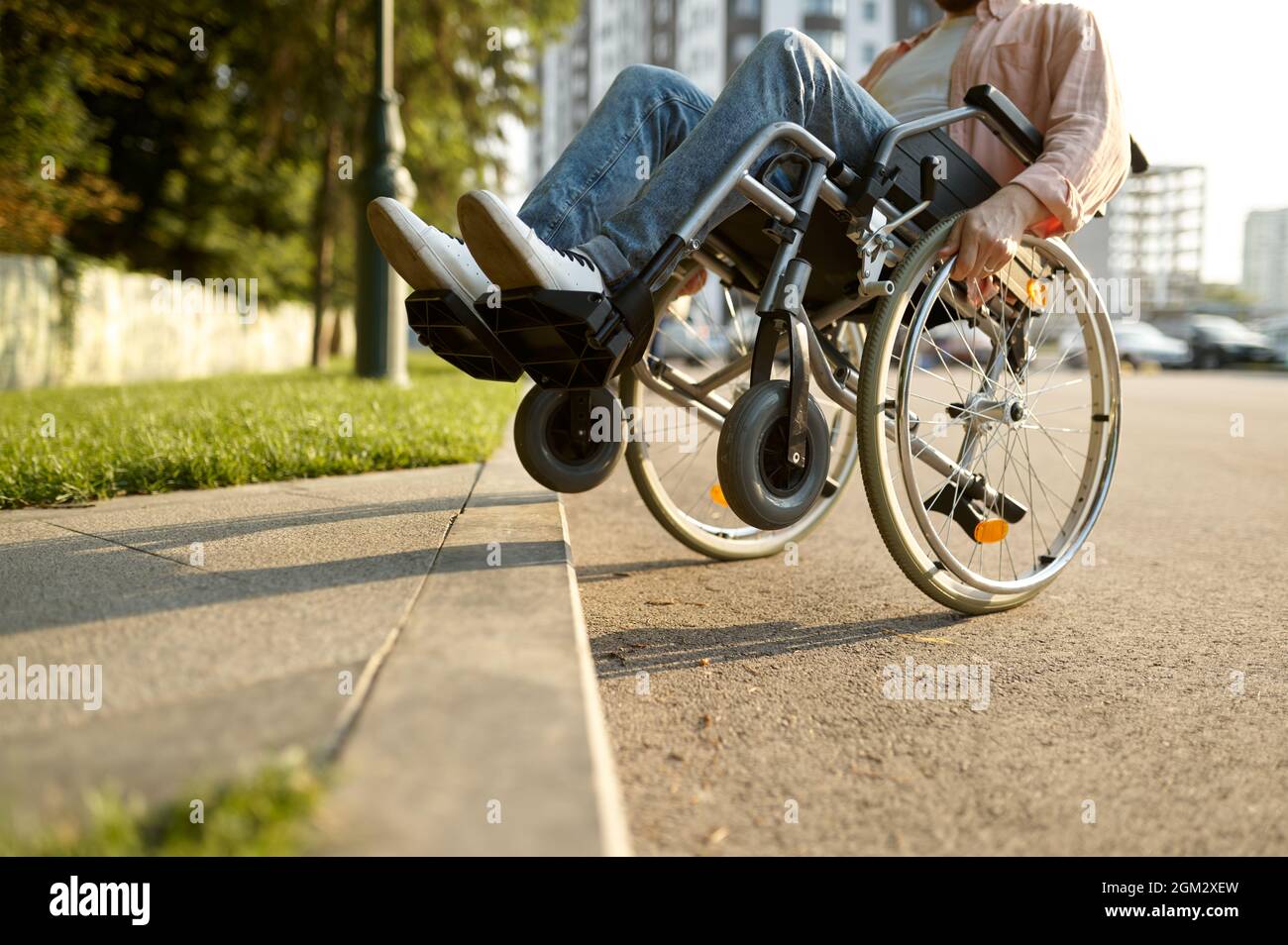 Disabled man in wheelchair overcomes the curb Stock Photo - Alamy