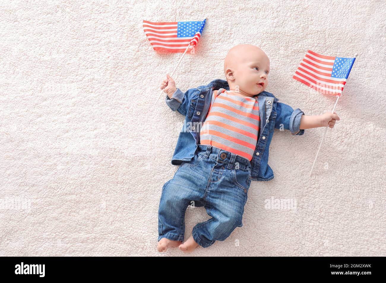 Cute baby with American flags on light background Stock Photo - Alamy