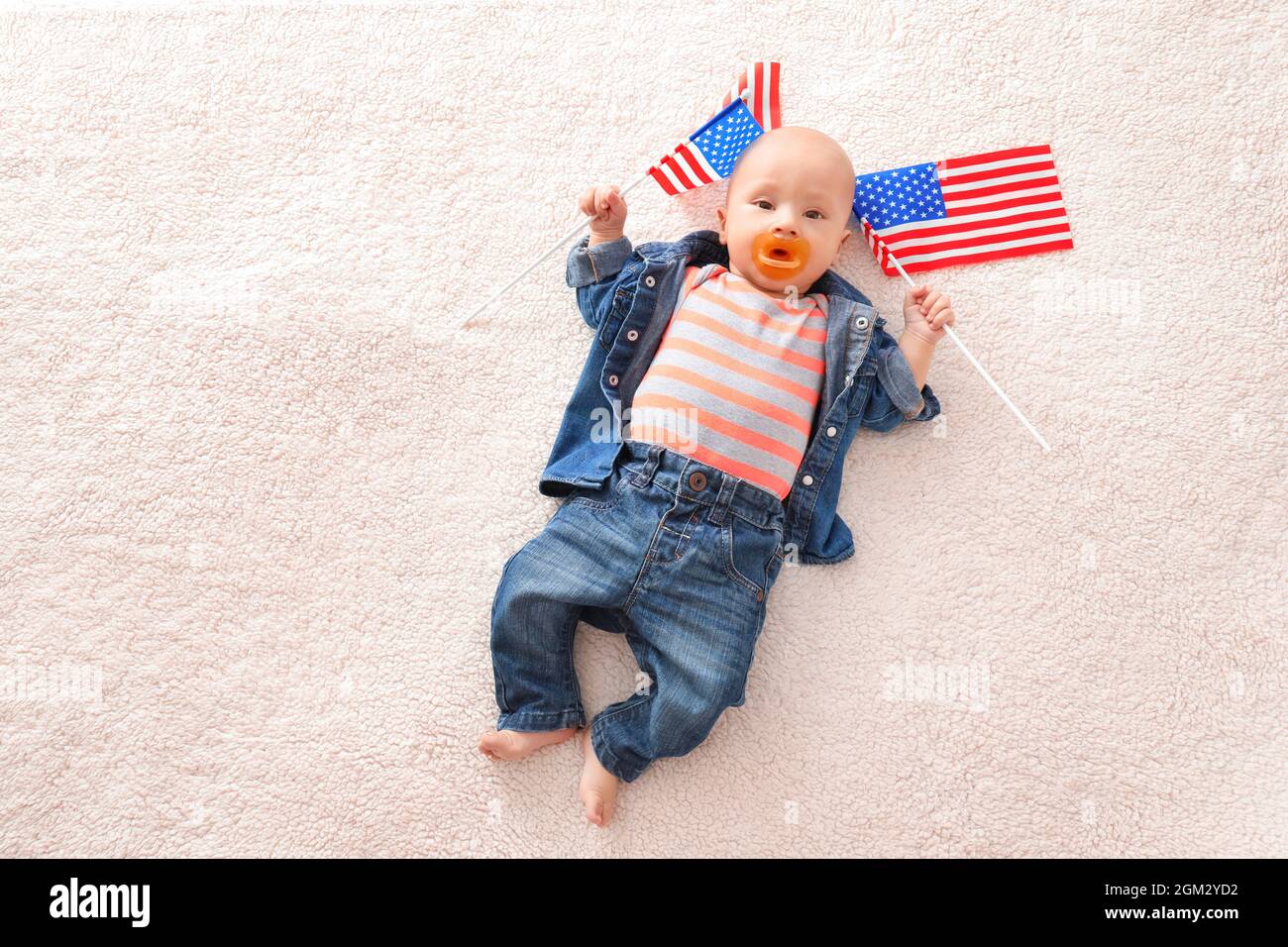 Cute baby with American flags on light background Stock Photo - Alamy