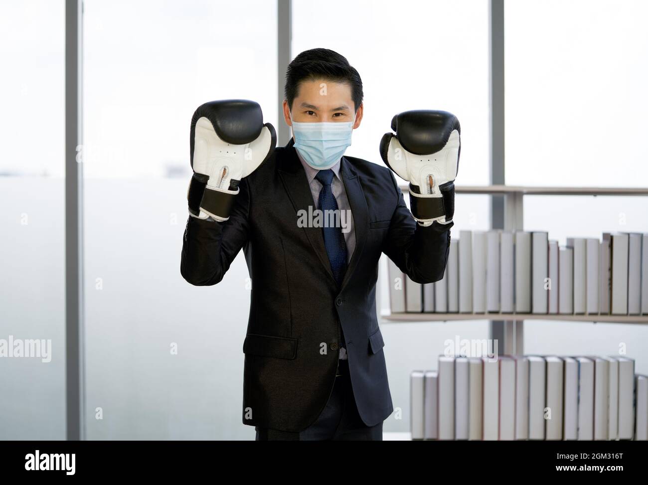Asian businessman dressed in suit and necktie, wearing a face mask and ...