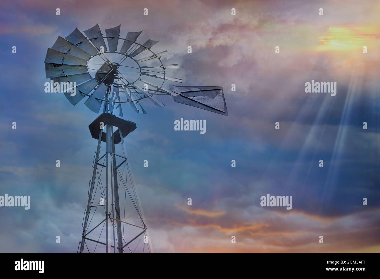 Wind mill against sun rays Stock Photo - Alamy