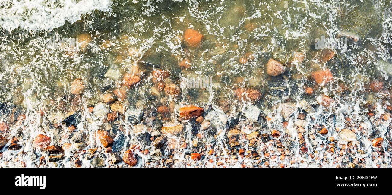 Sea waves slam into the sea rocks on the shore, sea foam on the shore ...
