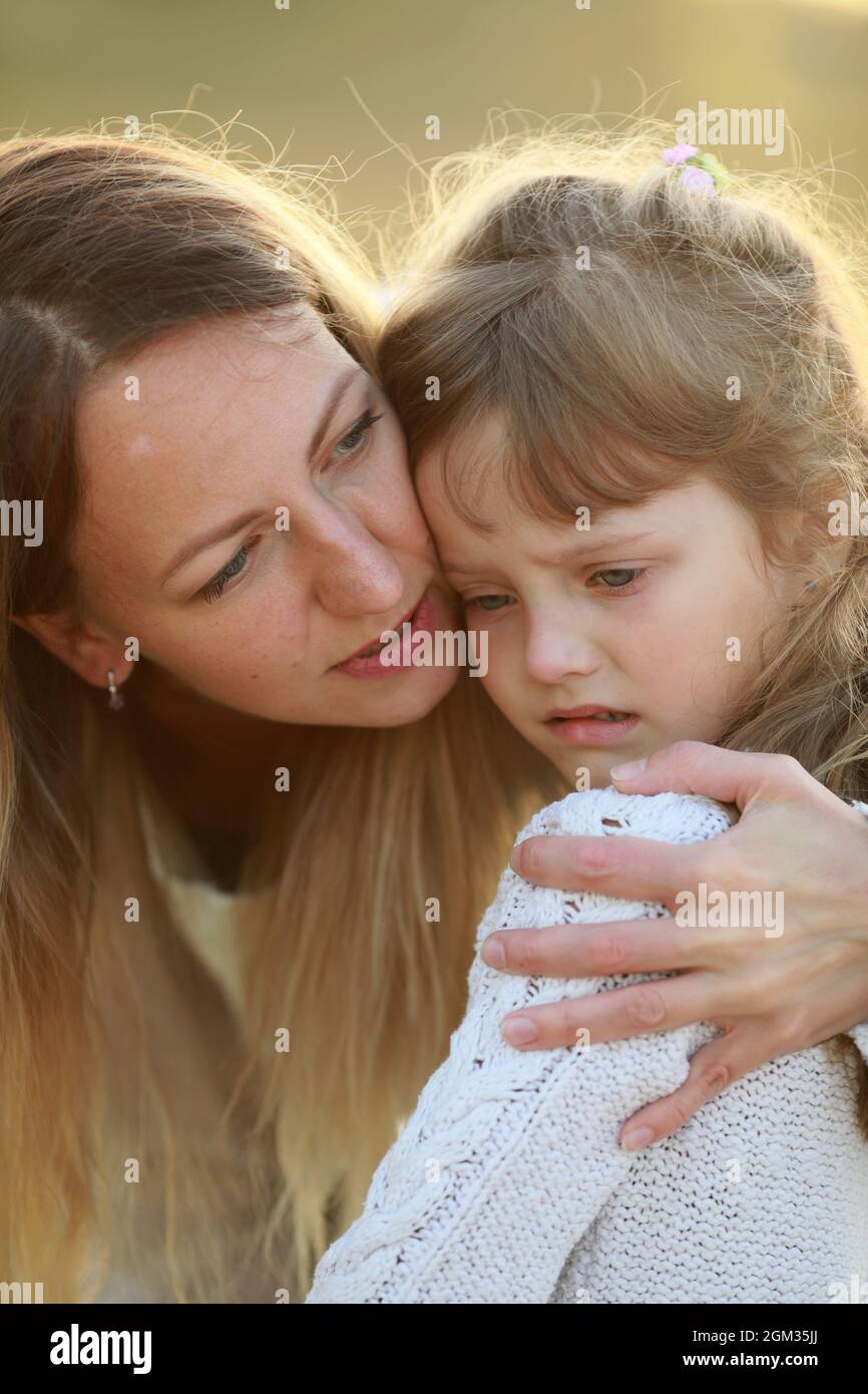 Mother comforts her crying resentful daughter while the walk. Portrait ...