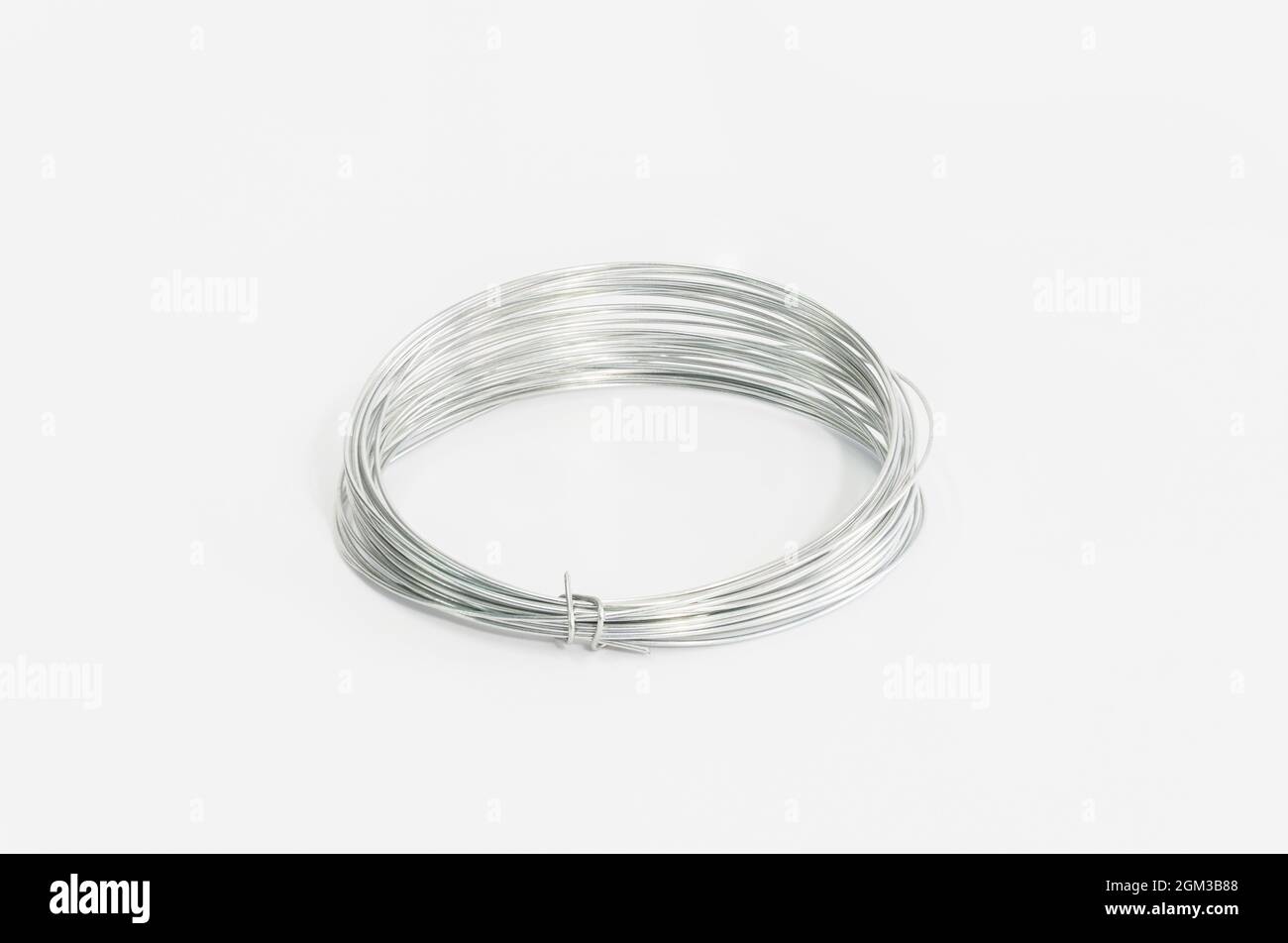 Steel wire round in a coil against stack isolated on white background ...