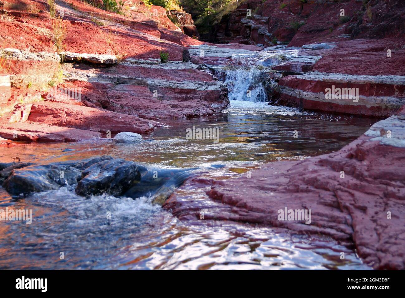 Cold water falling through the red rocks in Red Rock Canyon in Waterton ...
