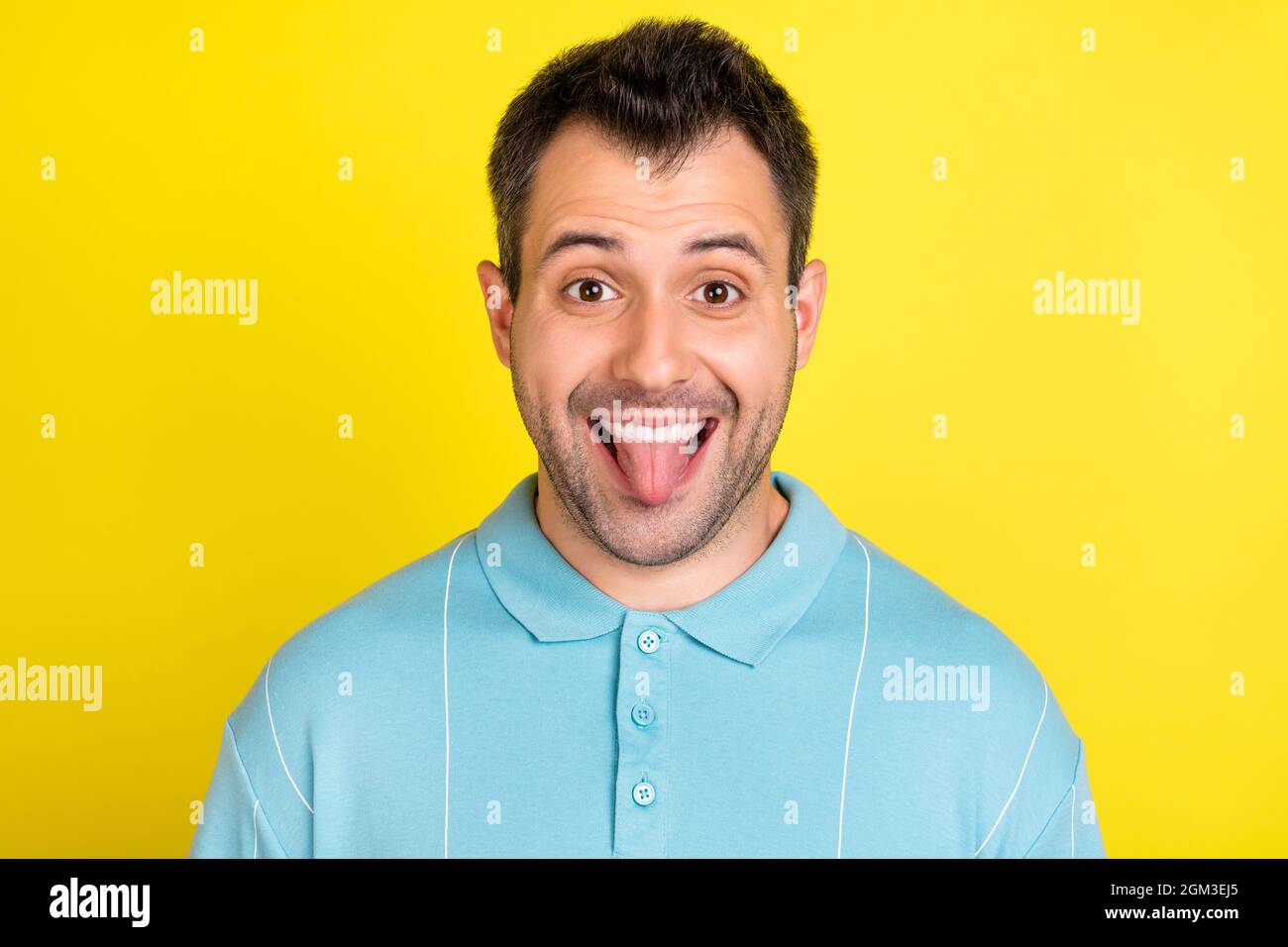 Photo of cool brunet man tongue out wear blue t-shirt isolated on ...