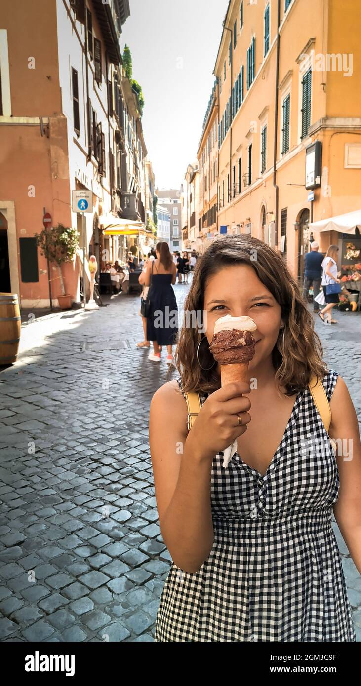 Portrait of young happy woman eating ice-cream, outdoor, Rome, Italy ...