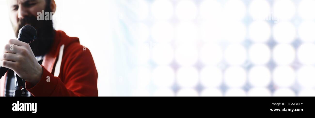 Stand with a microphone. Man holds hands a microphone on tripod ...