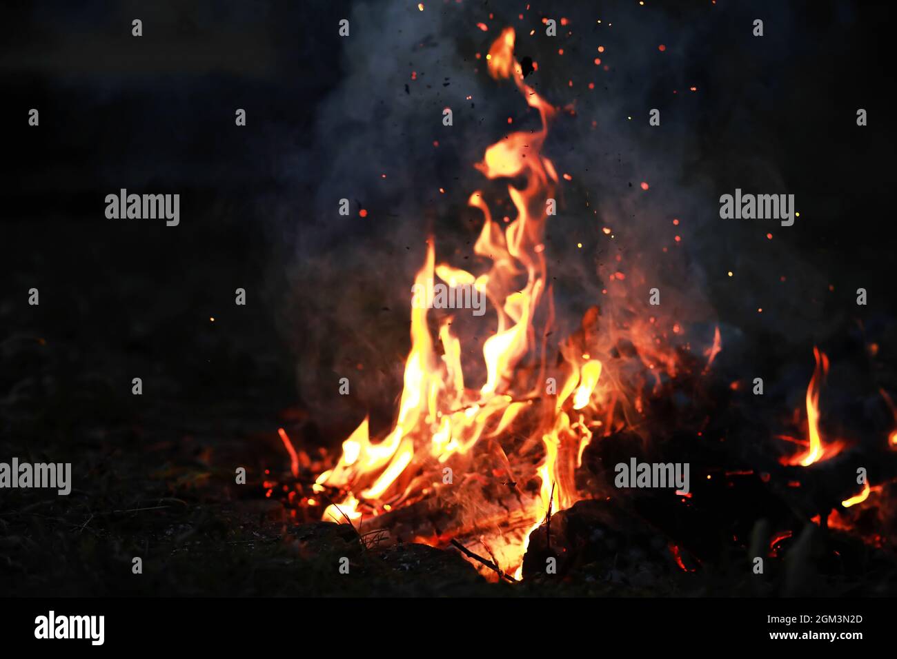 Burning red hot sparks fly from big fire. Burning coals, flaming ...