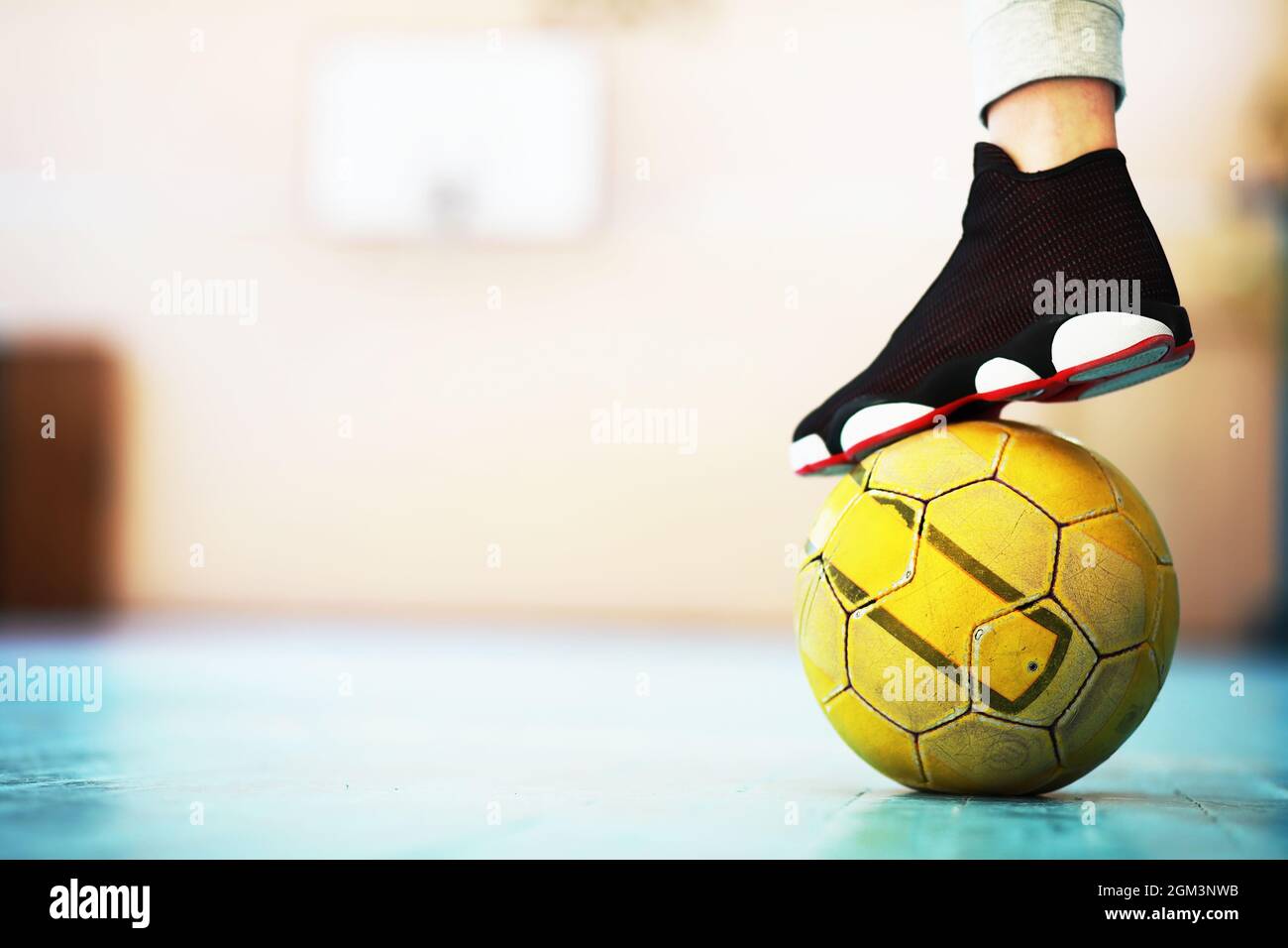 A human foot rest on the football on concrete floor. Photo of one ...