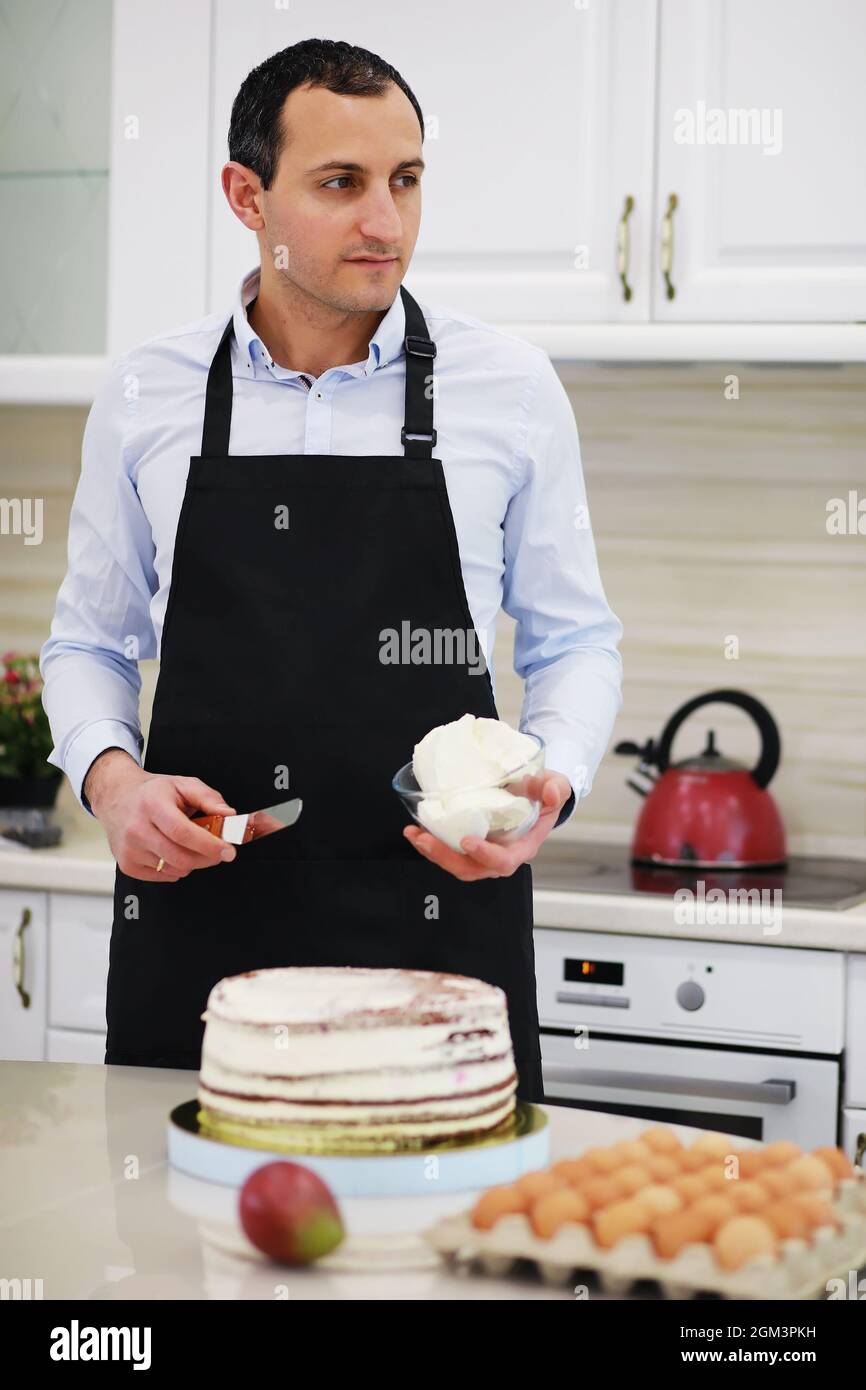 Master pastry chef in front of a desk. Cooking desserts at home. The ...