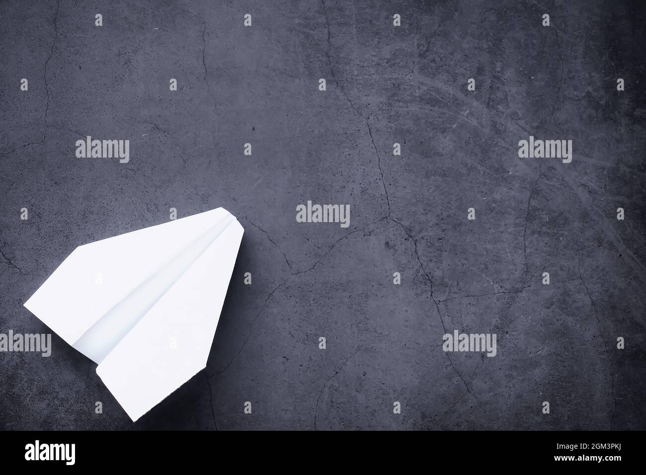 Paper airplane on the table. Origami model on a dark background ...