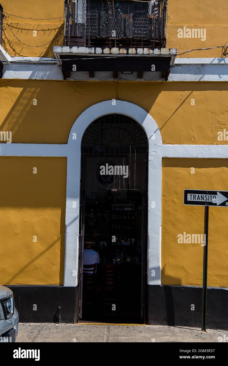 Yellow building with white arch along a street in San Juan, Puerto Rico ...