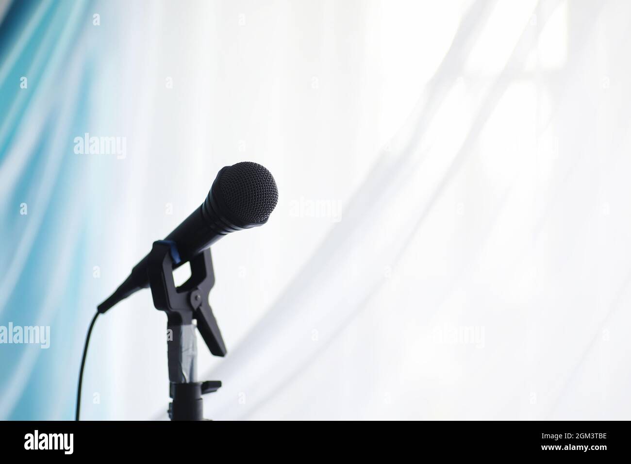 Stand with a microphone. Man holds hands a microphone on tripod ...