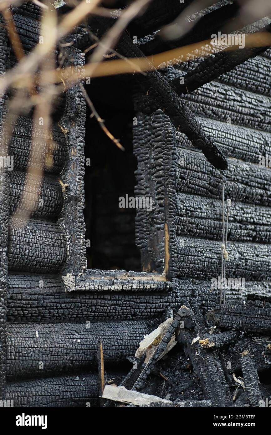 Wooden house after the fire. Coals on the logs. The ashes of the house ...