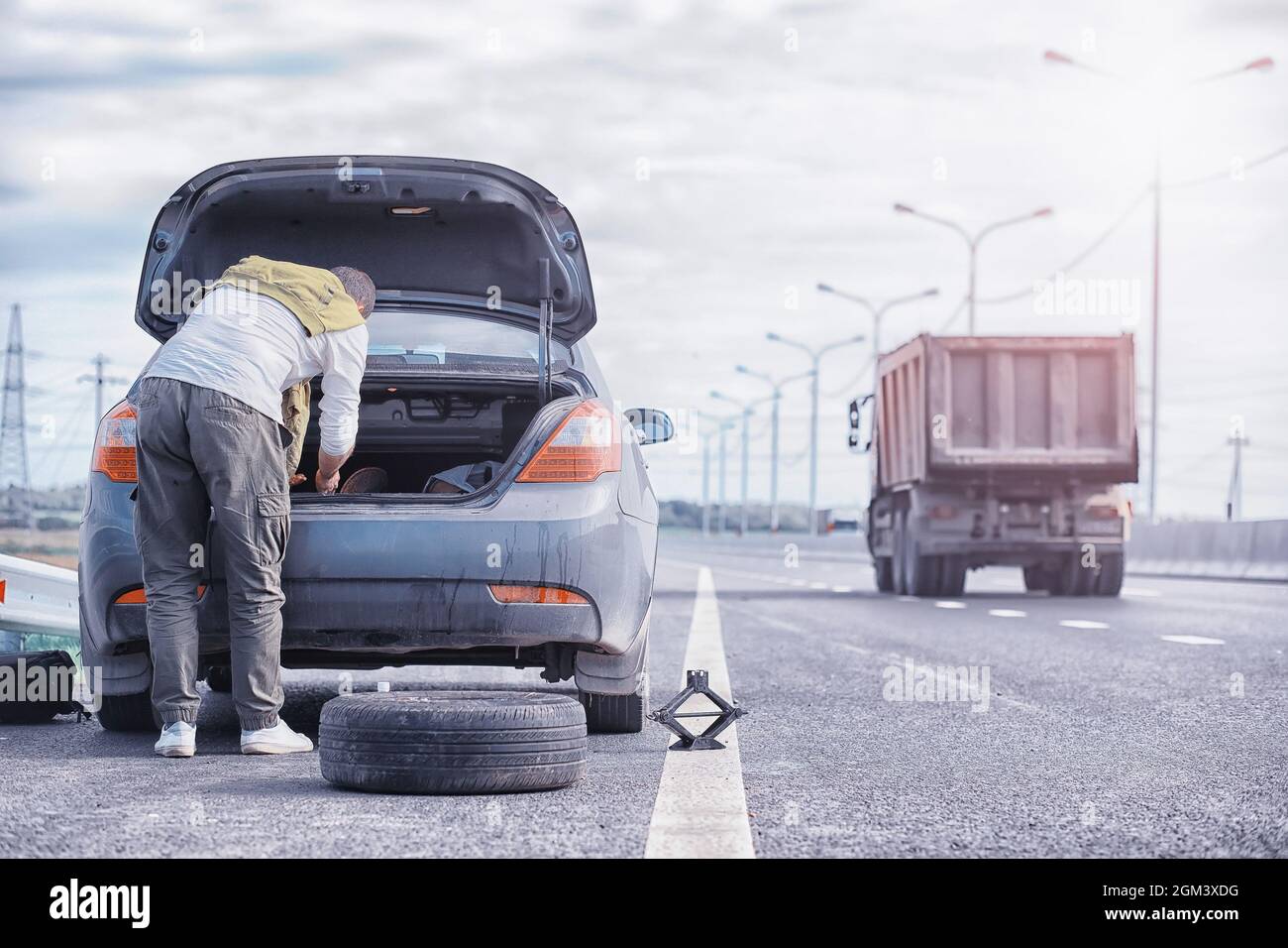 Replacing the wheel of a car on the road. A man doing tire work on ...