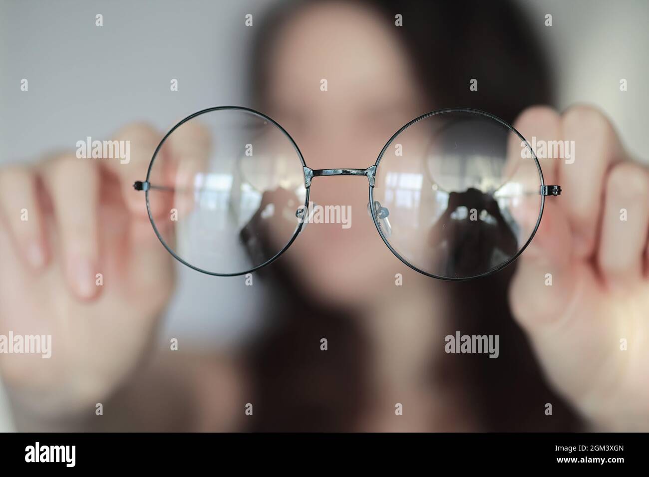 The concept of poor vision. Hold a contact lens and glasses in hand ...