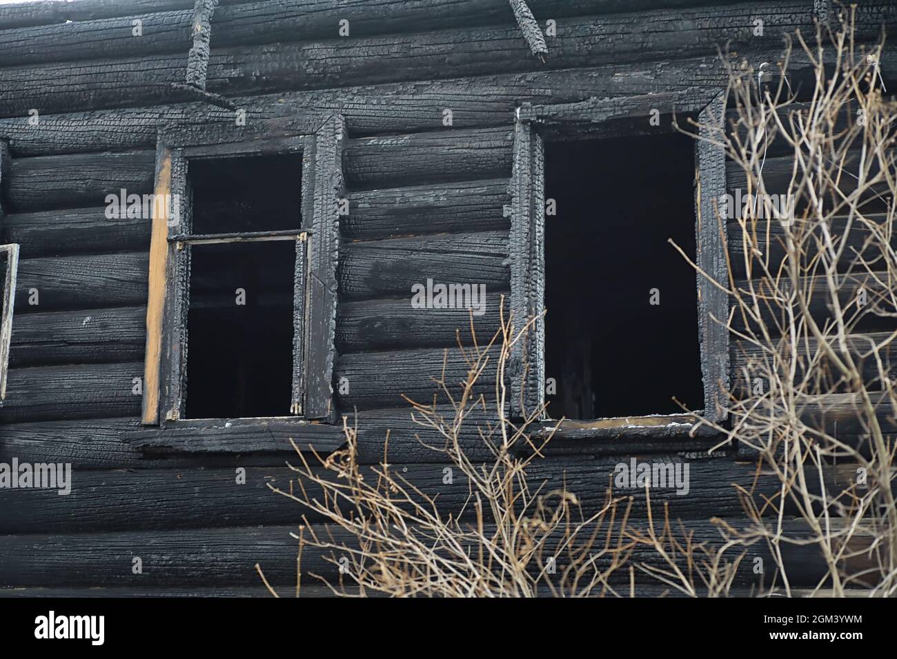 Wooden house after the fire. Coals on the logs. The ashes of the house ...