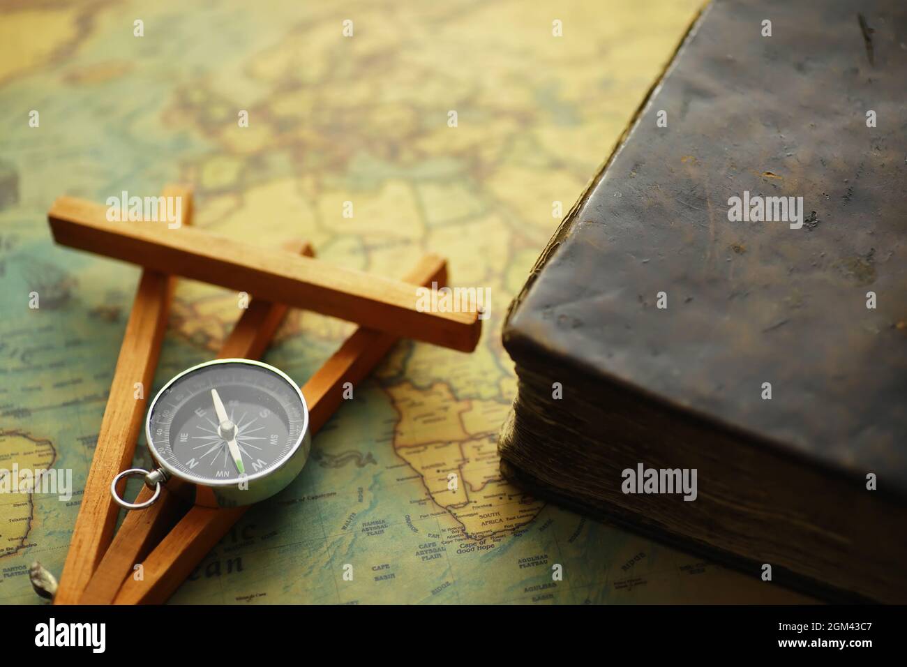 Travel and adventure search concept. Vintage aged map with shabby book ...