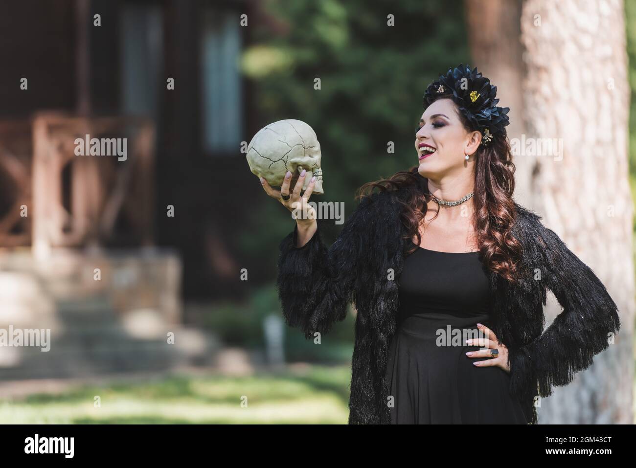 cheerful woman in vampire halloween costume standing with hand on hip ...
