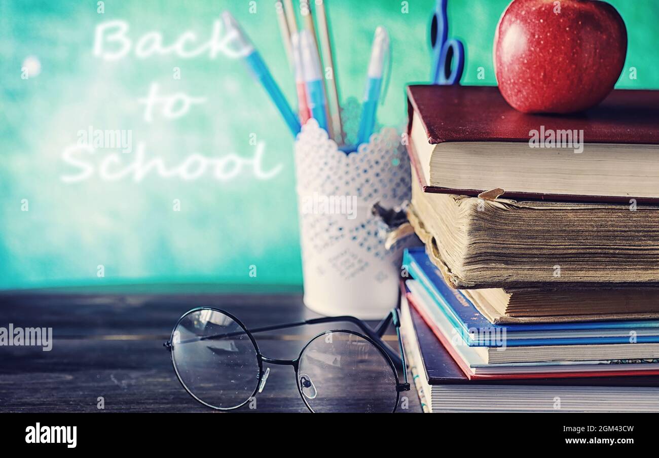 Education concept. A stack of textbooks and a book on the desk with ...