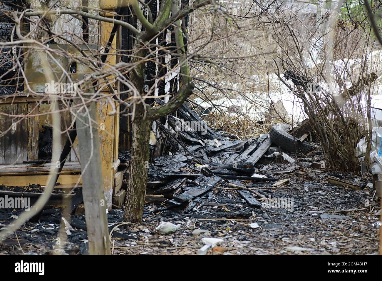 Wooden house after the fire. Coals on the logs. The ashes of the house ...