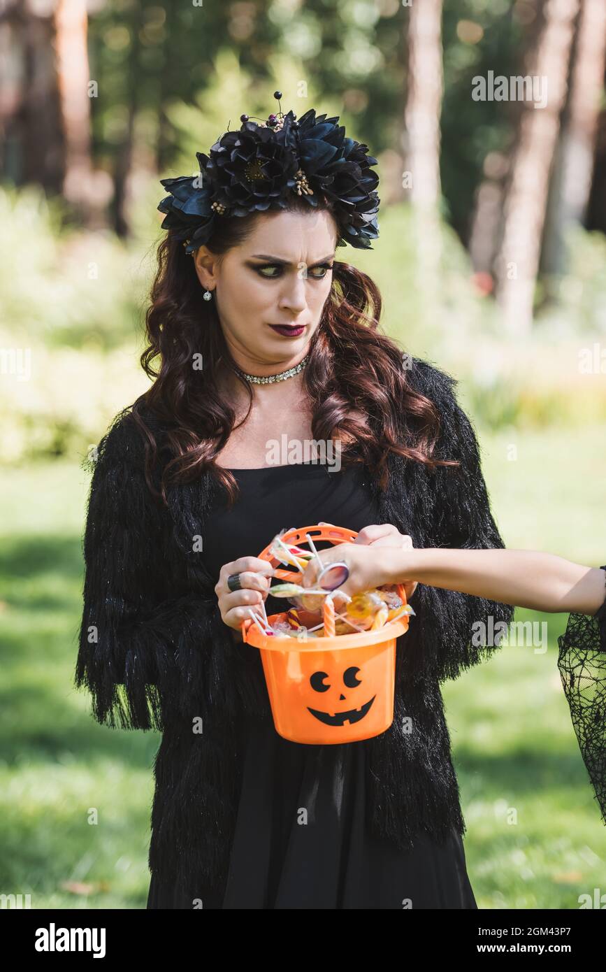 angry woman in vampire halloween costume near daughter stealing candies ...